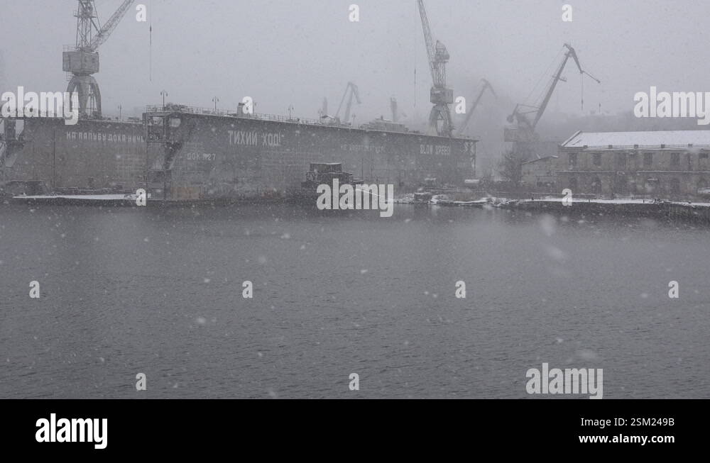View of an old inoperative lift dock on river amid heavy snowfall. Poor ...