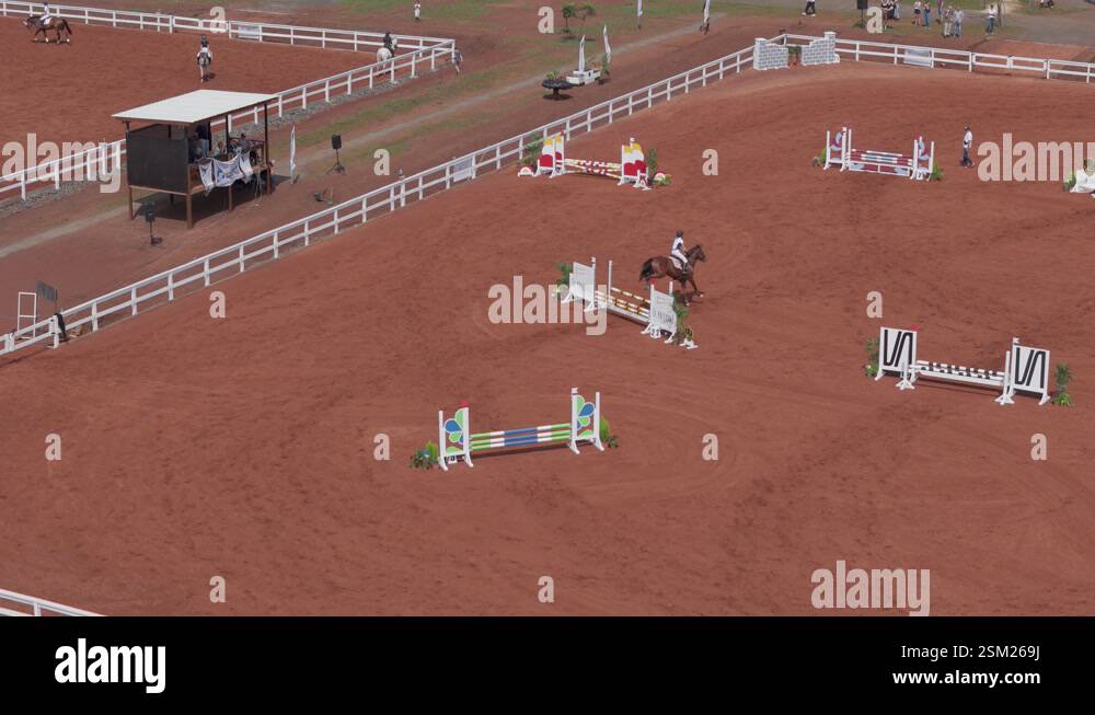 Horse rider performing jumps in the horse jumping barn Aerial View of ...