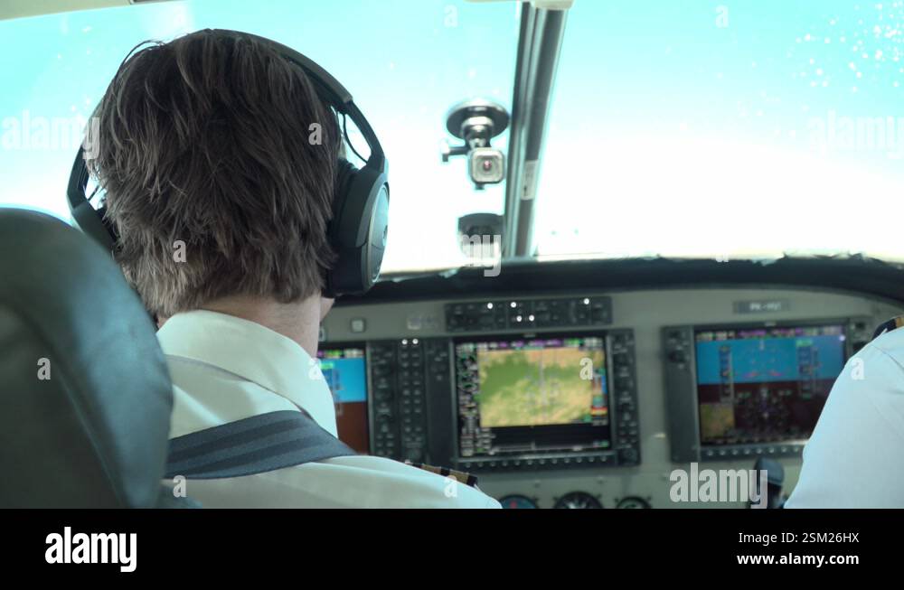 Pilot looking ahead on instrument panels and screens during a flight ...