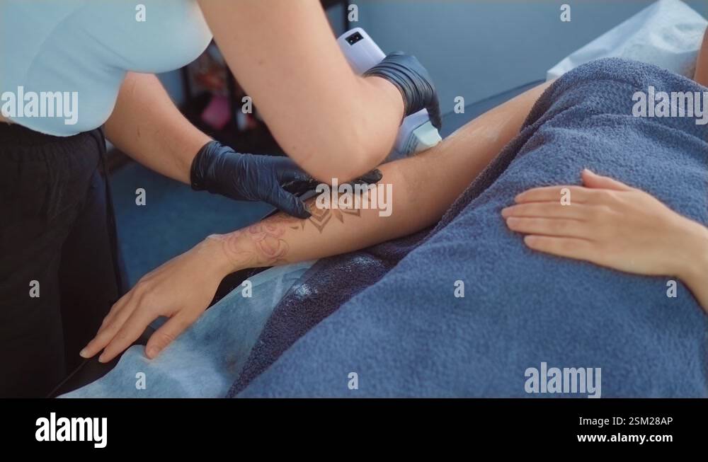 Woman undergoing waxing procedure, beautician applying wax strips at ...