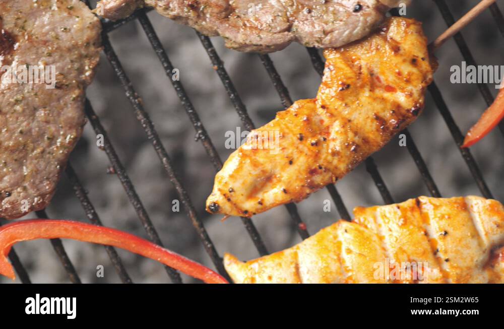 top down panning shot over grill grate with chicken steak and ...