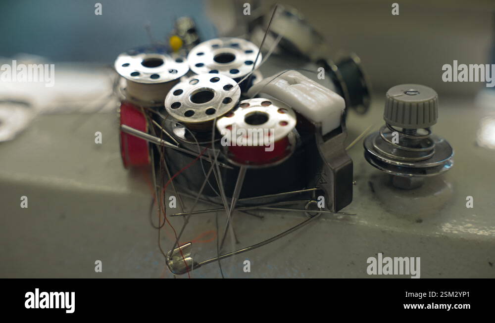 Small reels with colourful threads and fabric straight pins on the top ...