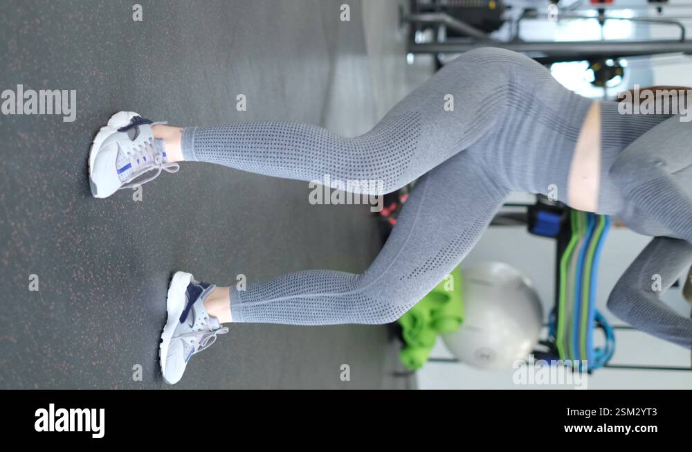Slim girl doing squats in the gym. Crossfit training. Vertical video ...