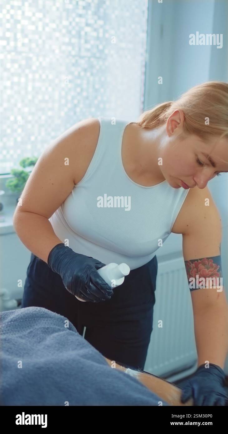 Woman depilatory expert applies sugar paste on patient hand in beauty ...