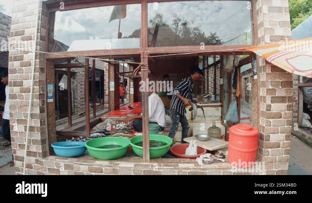 Young fishmongers in an Indian fish market are busy packing fish into ...