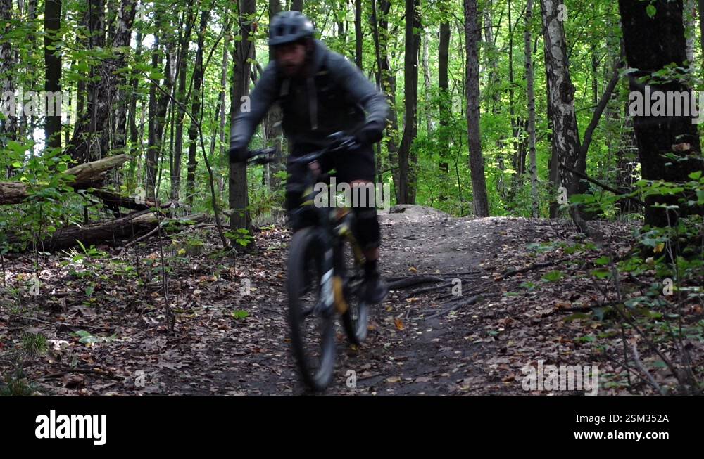 A static shot in slow motion of an adult male jumping on an emtb on the ...