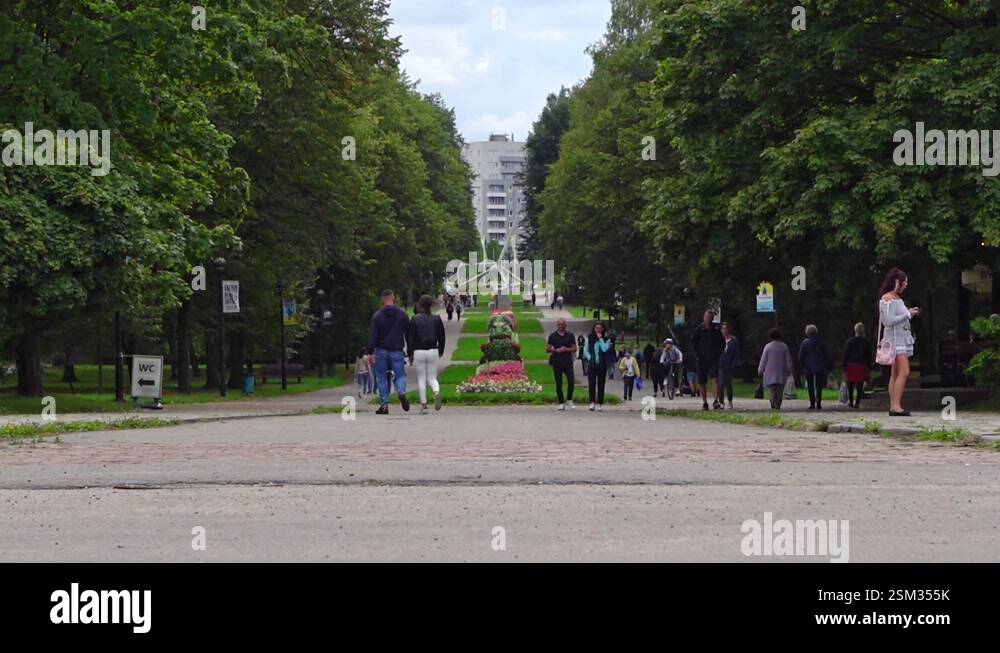 Static shot of people walking through the park in Chorzów in Poland, on ...