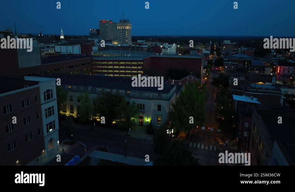 American city during blue hour at dusk. Aerial descending shot of ...