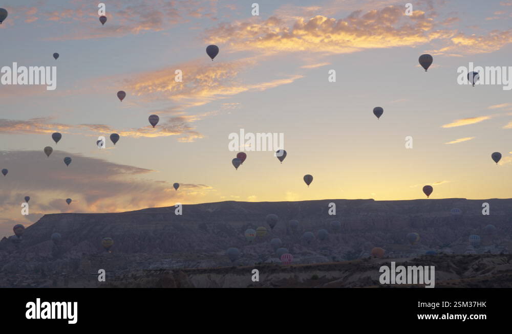 A beautiful sunrise in the canyon with hundreds of hot air balloons ...