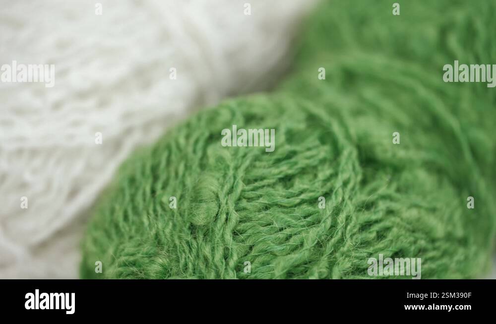 rotation of skeins of white and green wool yarn. concept of women hobby ...