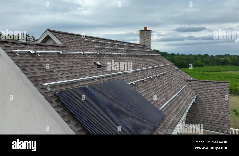 Solar panels on shingle roof of house in USA. Aerial rising shot ...
