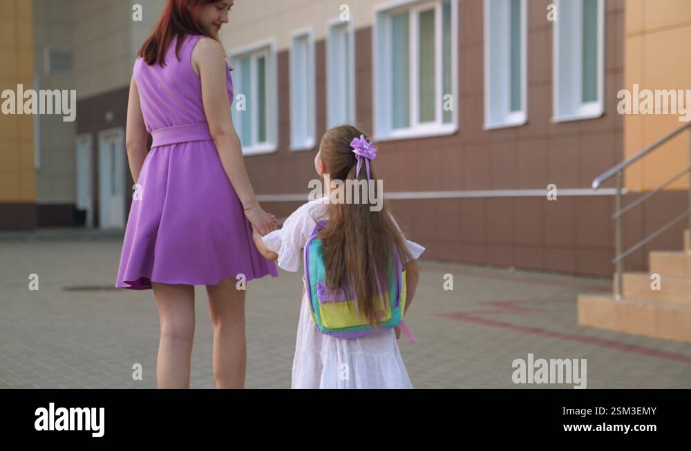 first grader goes school holding her mother hand. happy family. climb ...