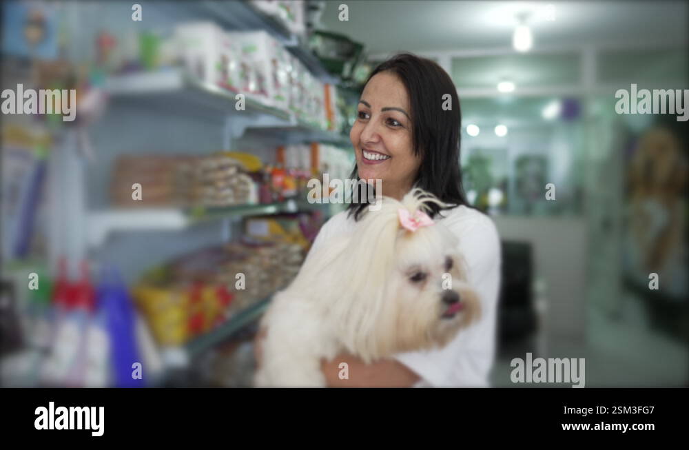 Woman Holding Small Dog While Browsing Pet Products in Store Stock ...