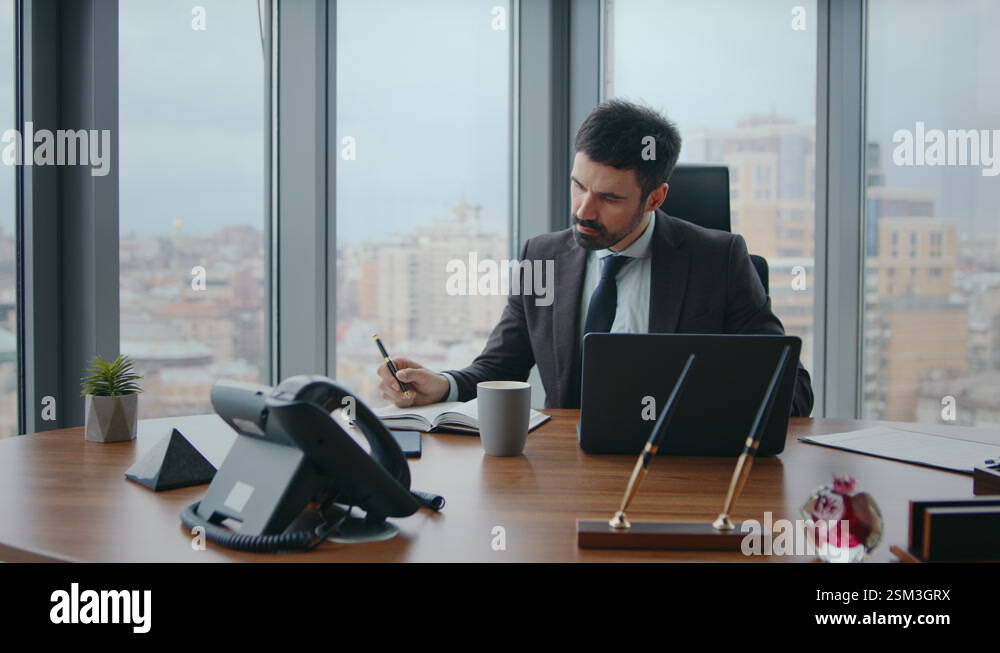 Pensive manager making notes working by laptop closeup. Ceo writing ...