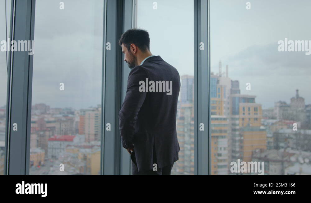 Busy ceo calling partners standing office window. Boss giving tasks by ...