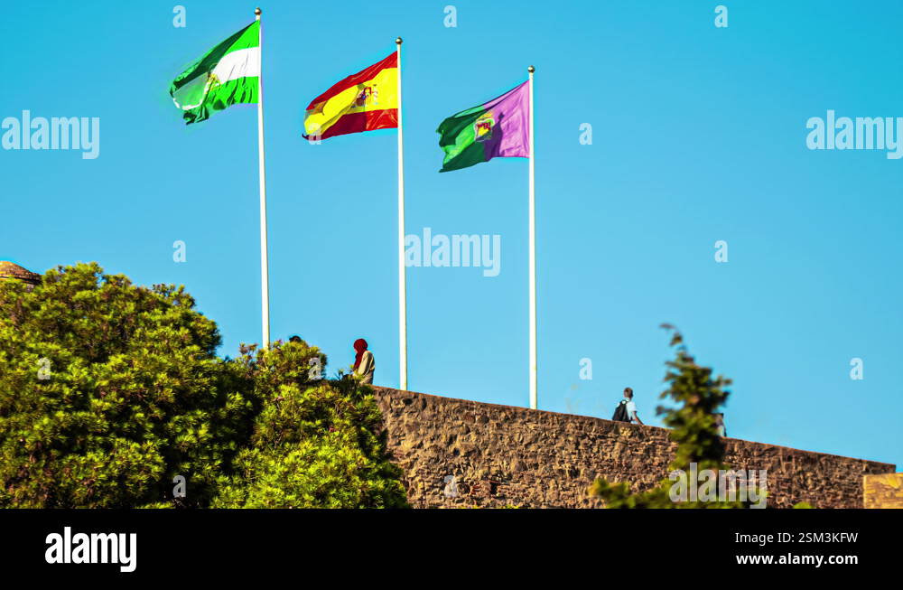 Spain, Malaga and Andalusia flags wave in wind on sunny day, time lapse ...