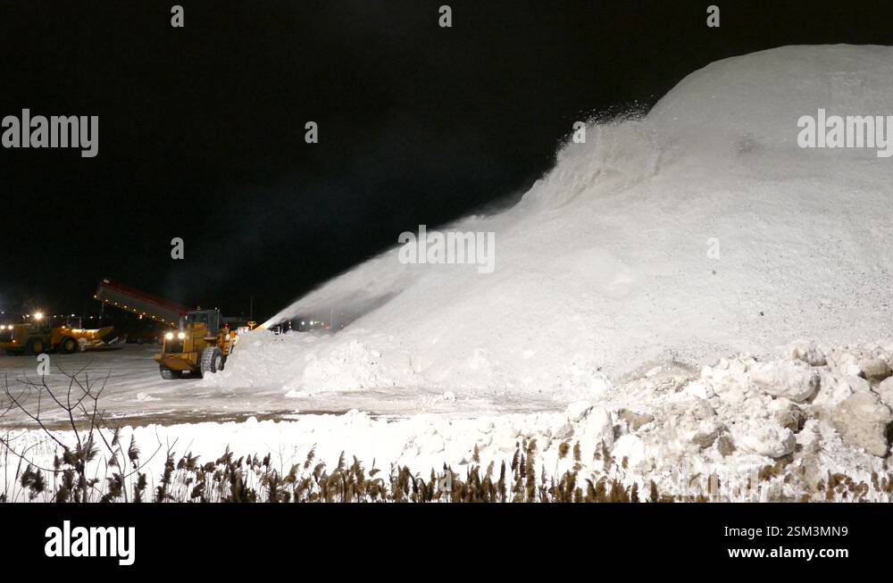 Larrue loader-mounted blower blasts snow up onto the mound at the ...