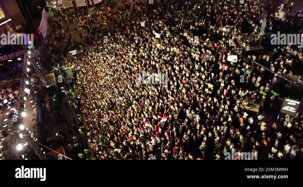Aerial Bird Eye shot for crowd in front of stage concert at night with ...