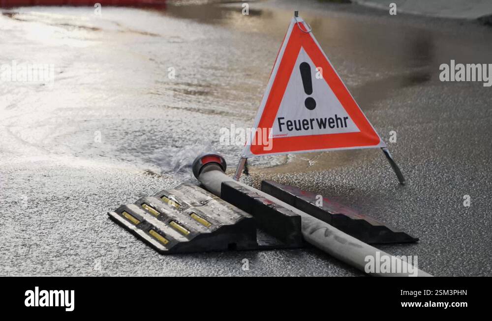 Fire department warning sign besides water hose during flood to pump ...