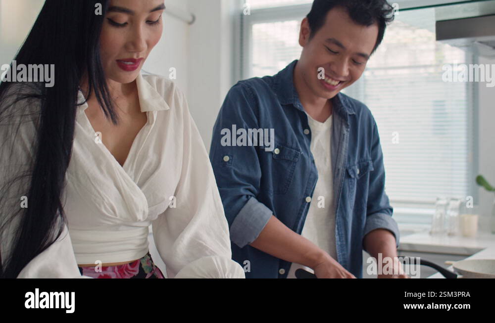 Laughing Asian Couple Cooking Salad at Home Stock Video Footage - Alamy