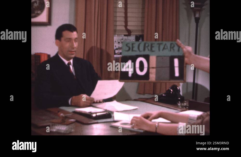 1940s: Clapperboard. Boss reads from sheet of paper and secretary takes ...