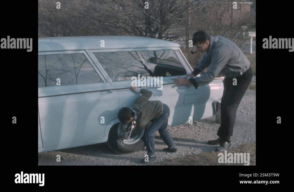 1960s: Clapperboard. Father and son clean car with rags and bucket ...