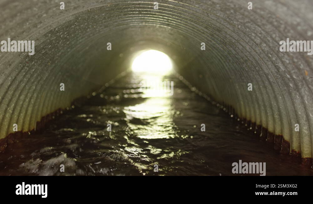 Rainwater flowing through corrugated stormwater drainage pipe, pedestal ...