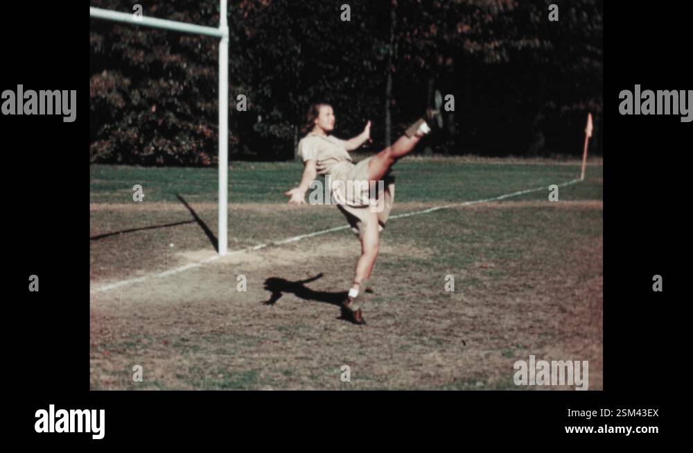 1950s: Slow motion shot, girl kicking ball. Girl stops ball, kicks ball ...