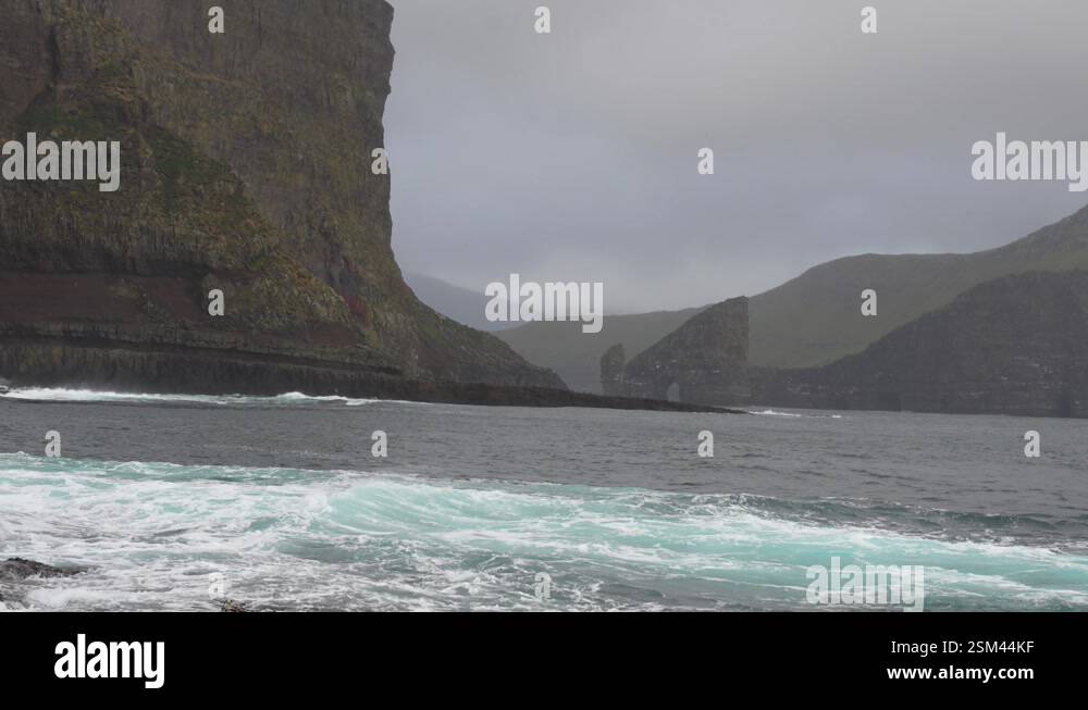 Close up shot of the North Atlantic Ocean waves in front of Tindholmur ...