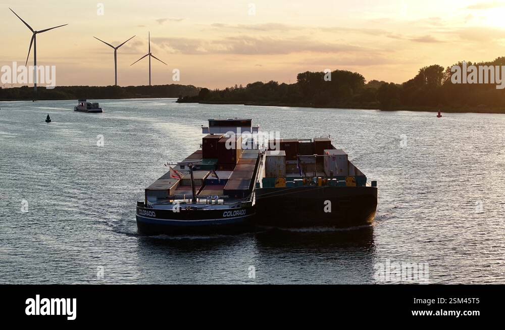 Two cargo ships tied together sailing on a river carry containers ...