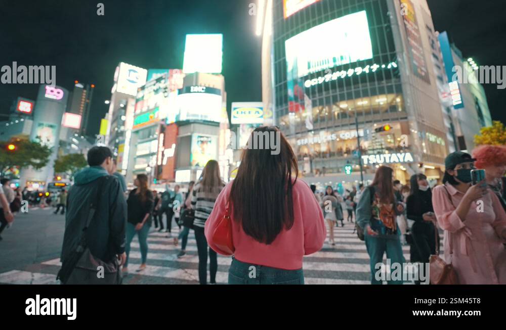 Back view of woman walking on pedestrians crosswalk, at Shibuya in ...