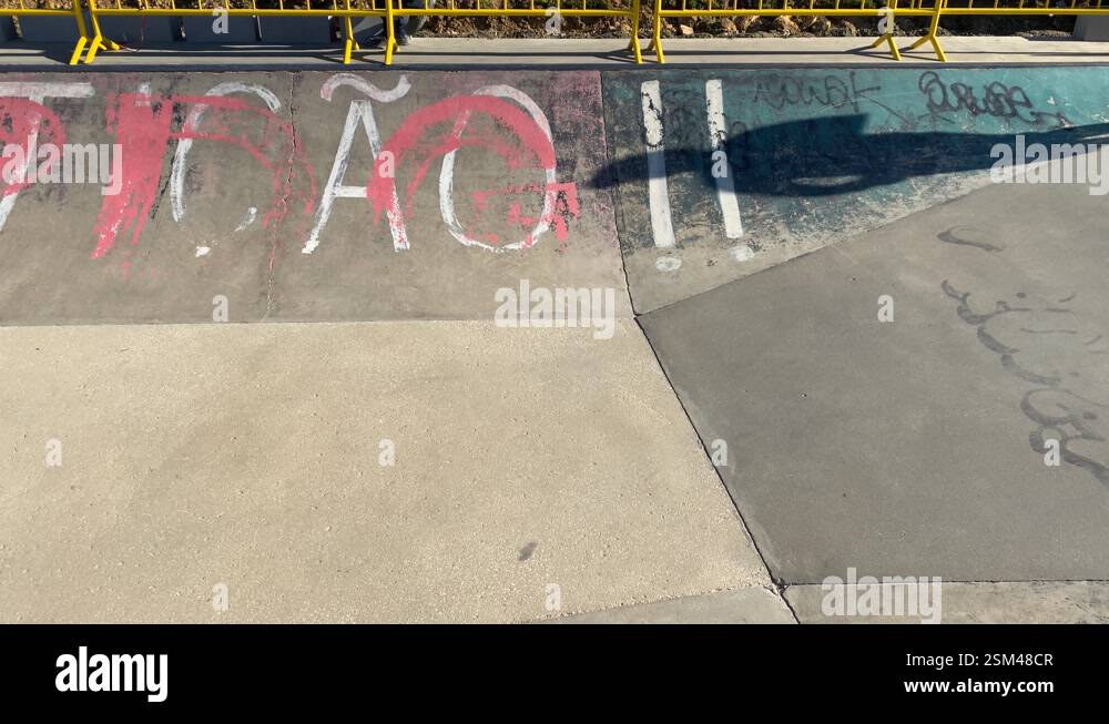 Shadow of an athlete preparing to descend the ramp at the skatepark ...