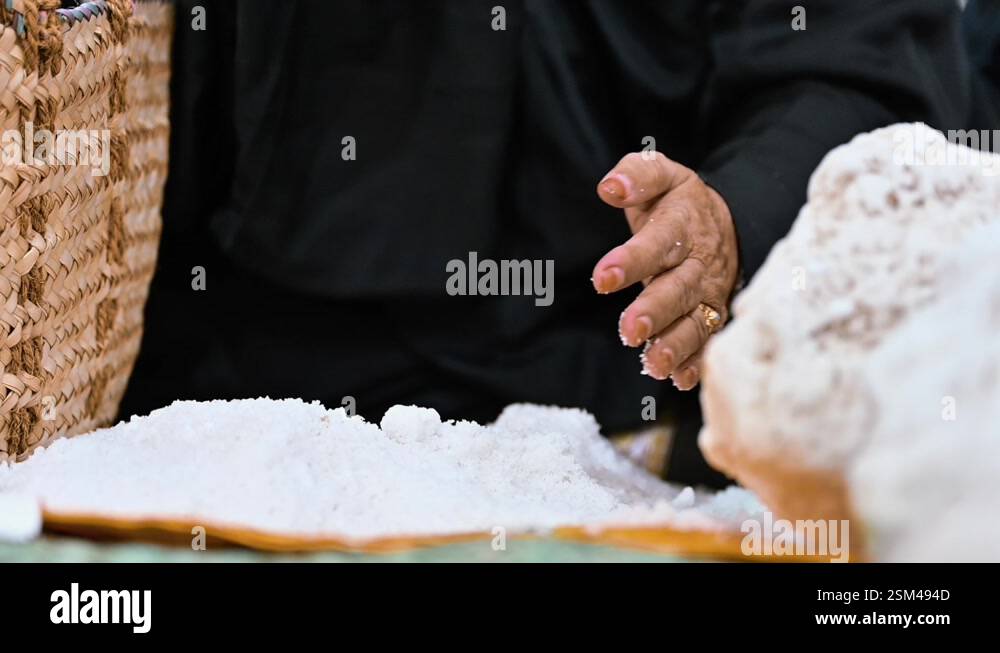 An Arab woman Pulverizing the sea salt by hand, traditionally using a ...