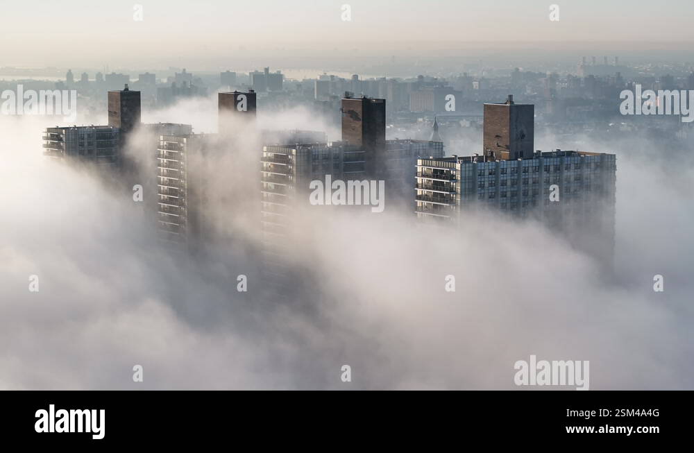 Aerial view of a high rise apartment complex peeking through the clouds ...