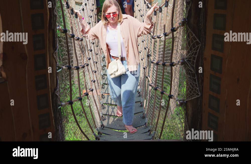 Woman afraid of heights and walking on a suspension bridge Stock Video ...
