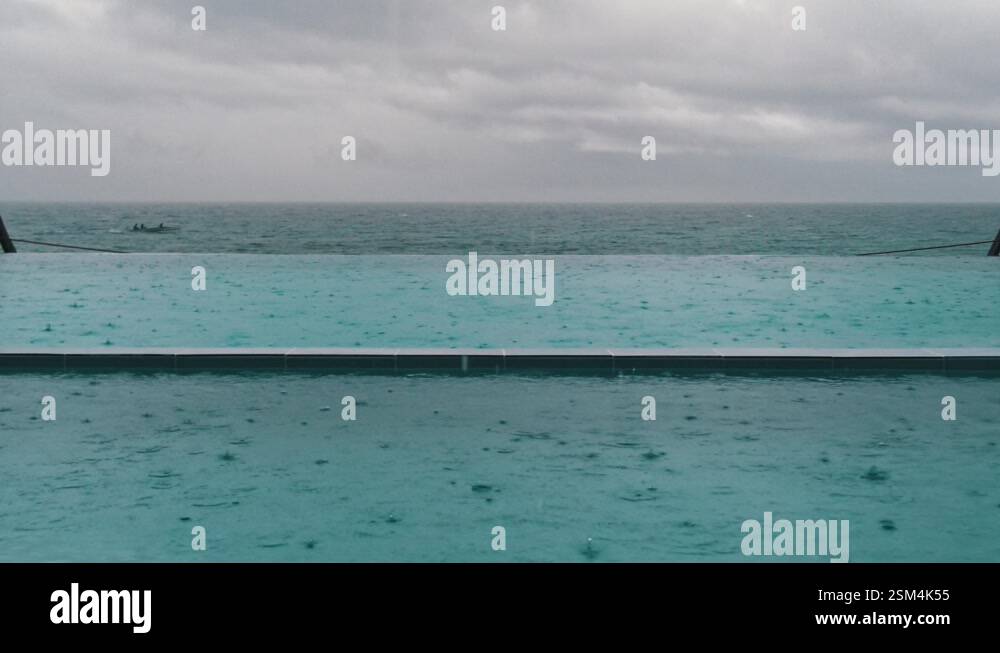 Still clip of rain drops falling on the water surface in a beach side ...