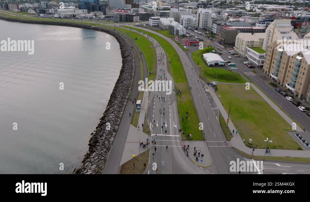 People running the Reykjavik marathon in Iceland along sea shore ...