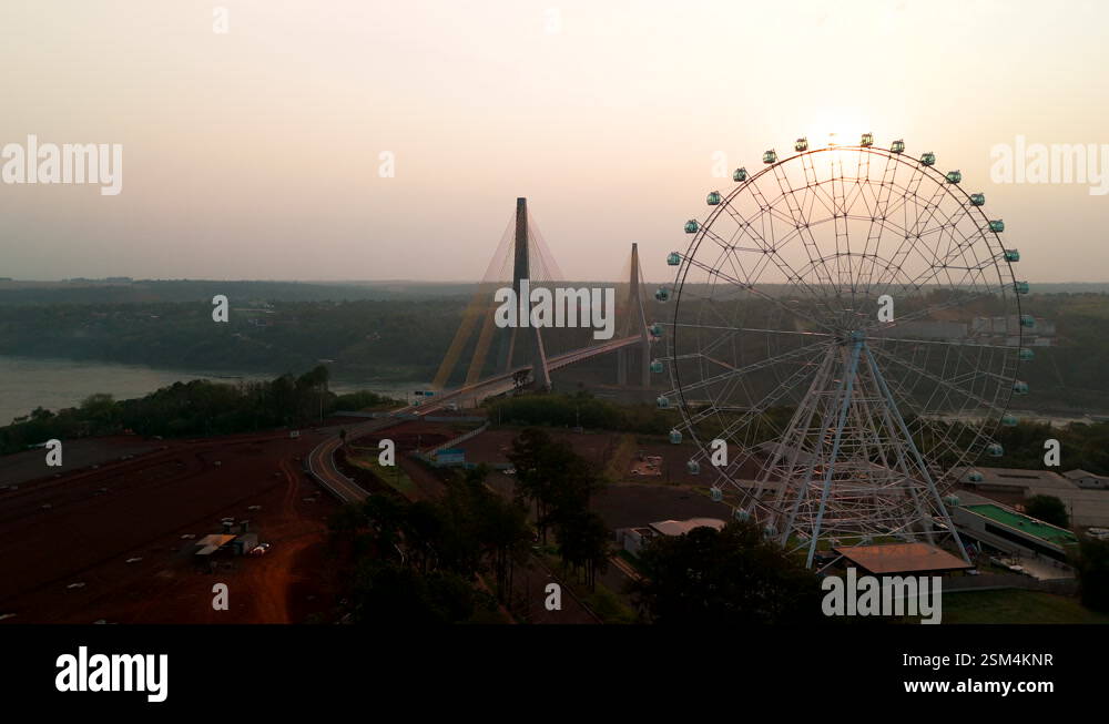 A breathtaking sunset over a Ferris wheel and a bridge at a unique ...