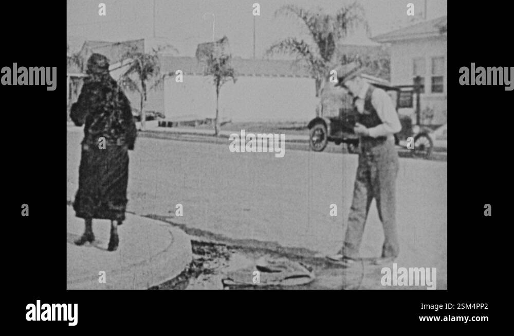 1920s: Man lays a coat over a puddle. Woman steps to the curb. Animated ...