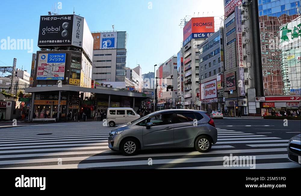 Crowd of people crossing a busy road crossing in Shinjuku Toyko, Japan ...