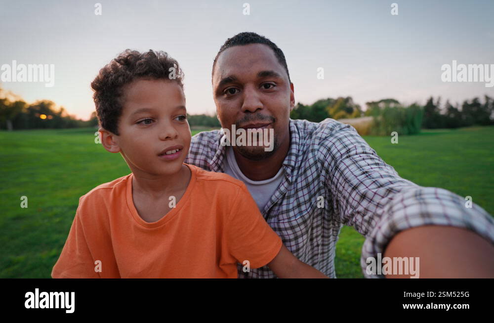African american dad and son recording video vlog at park Stock Video ...