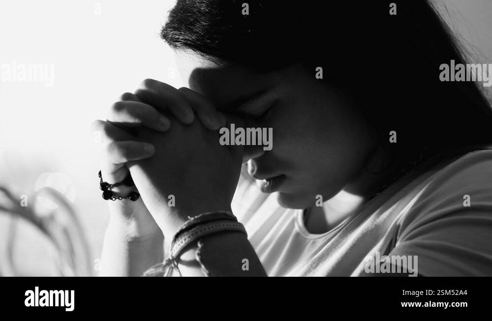 Dramatic Devotion of young woman Praying to God in monochrome black and ...