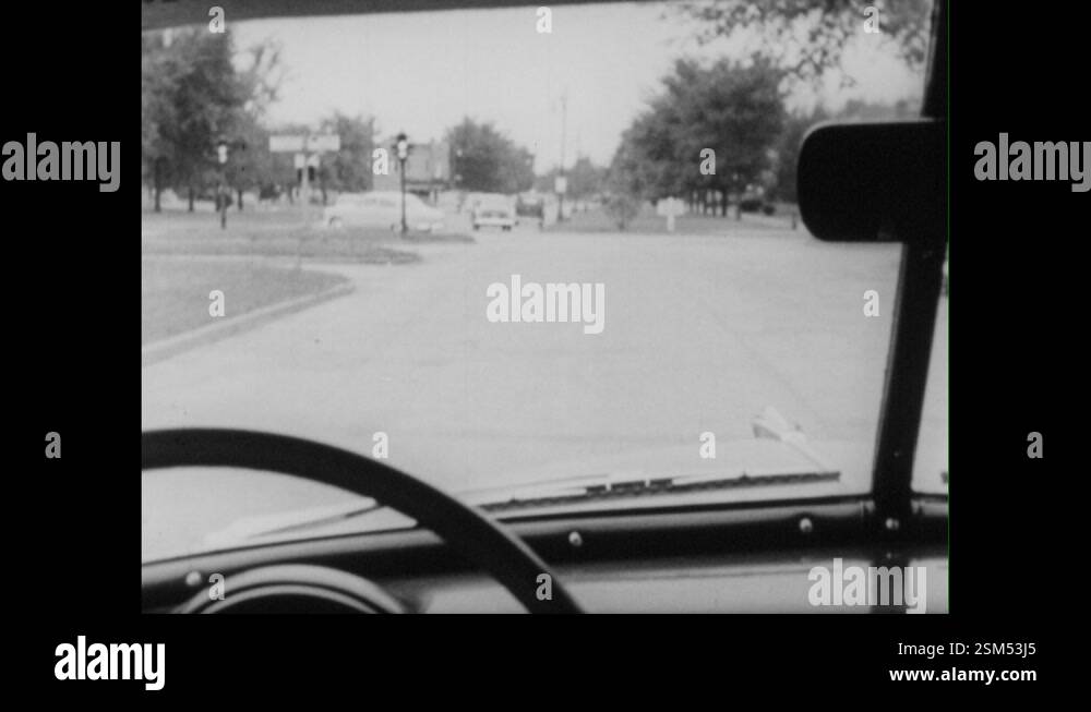 1950s: Driving in car down road. Car pulls to stop. Driver in car. Feet ...
