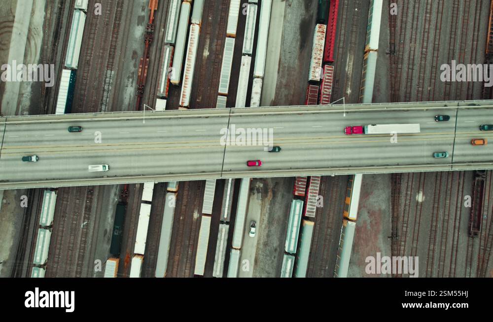 top down aerial of a bridge overpass above multiple rail roads with ...