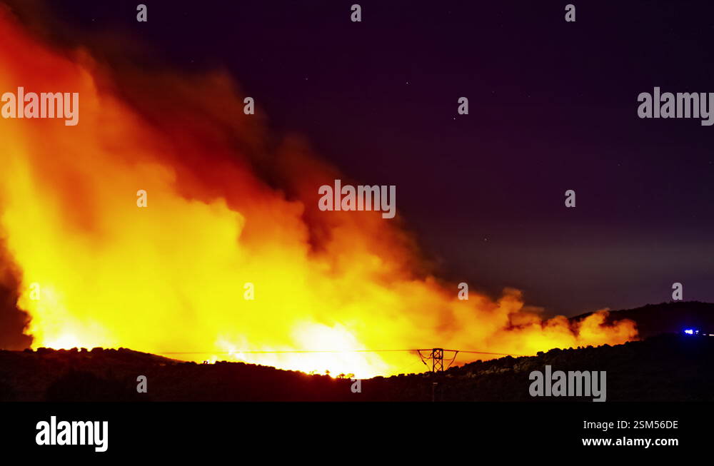 Very large forest fire with high rising flames near a power line Stock ...