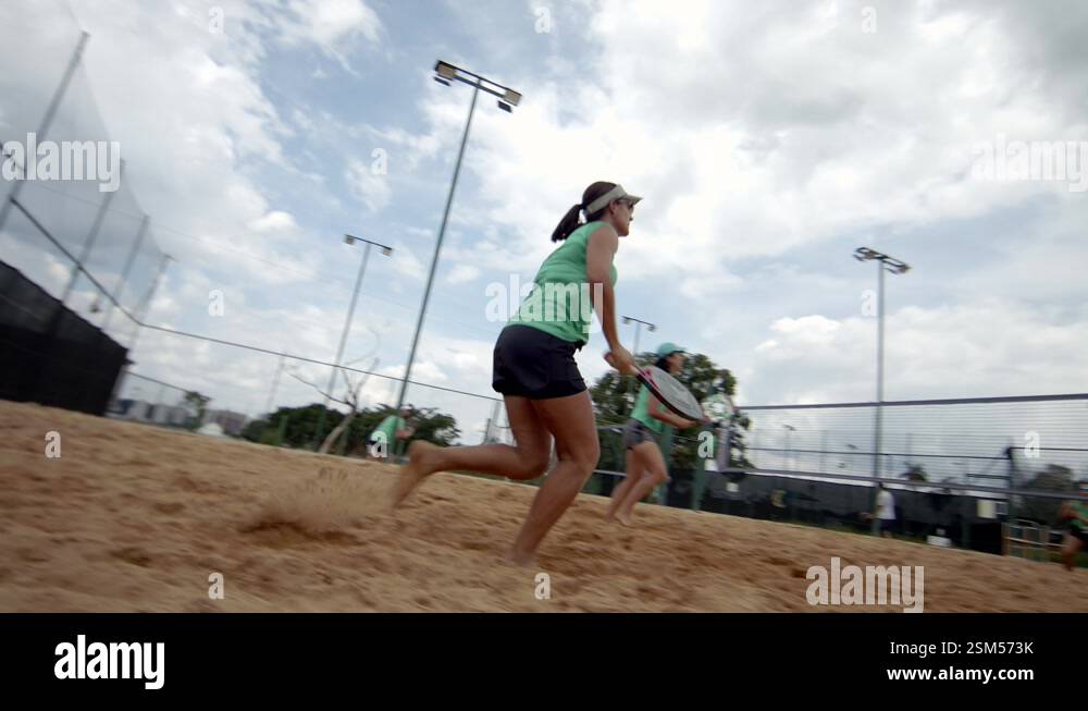 Acrobatic moves in action as beach tennis players jump and dive to make ...