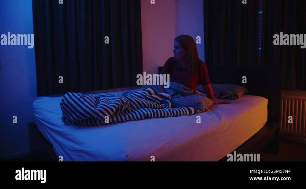 Woman waking up from nightmare and looking around in bedroom. She ...