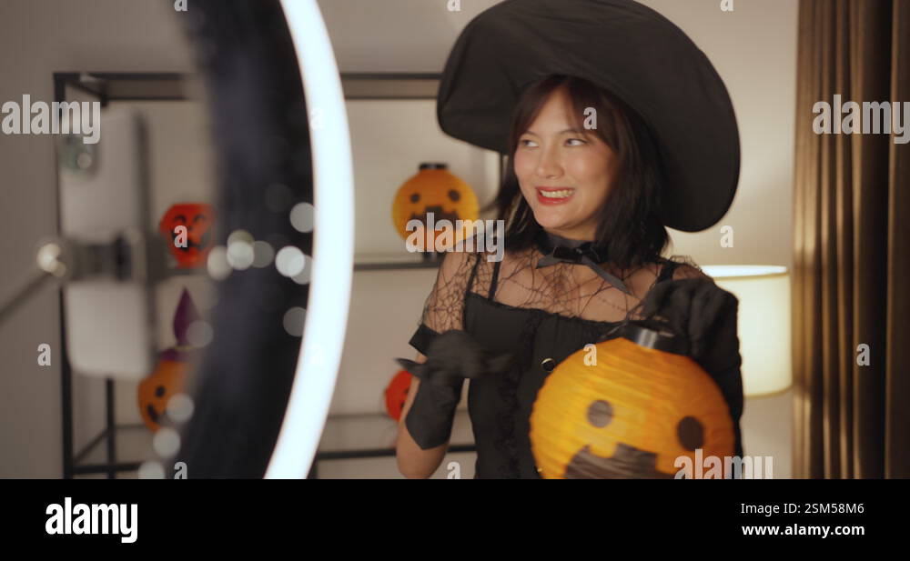 Female influencer wearing witch costume and live streaming at home ...