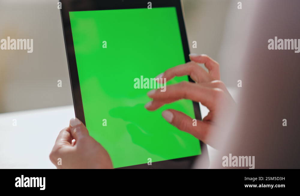 Woman hands swiping green screen tablet watching social media at home ...