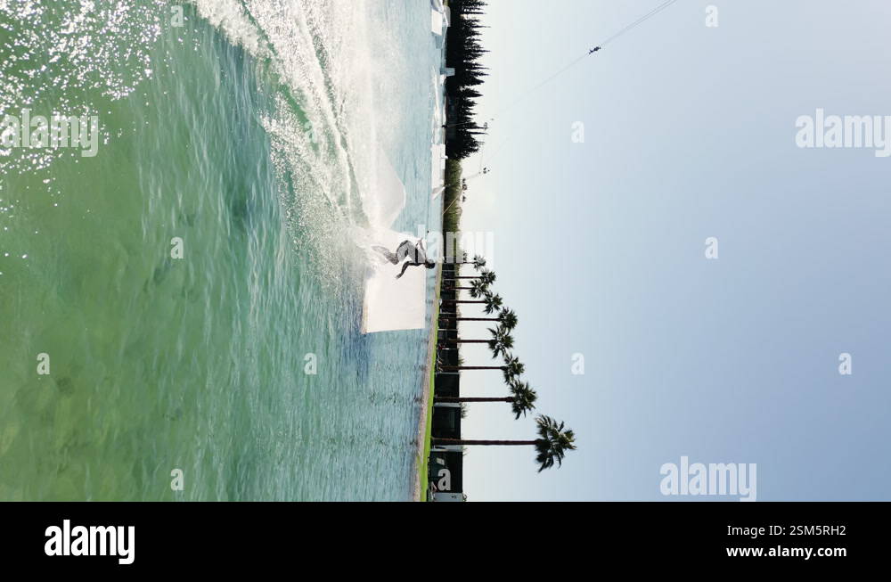 Tricks and skills of wakeboarder as he twists and turns going over ramp ...